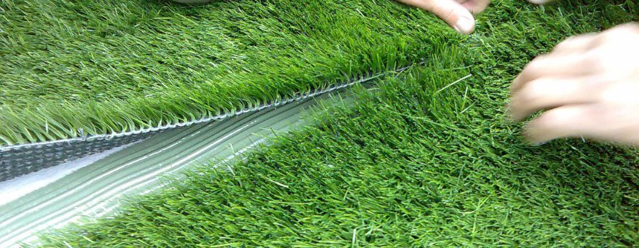 Pose d'un gazon synthétique sur de l'herbe